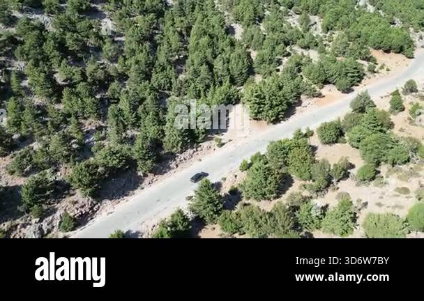 Adventure drive: drone footage of a single car traversing a remote mountain road through the ...