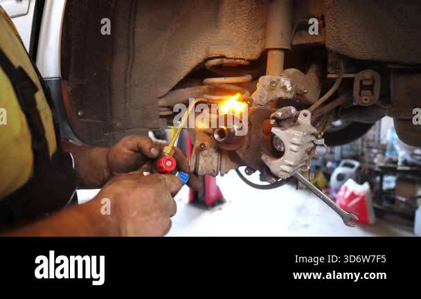 Mechanic skillfully applies heat to brake components, demonstrating the ...