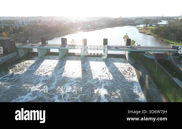 Aerial perspective of a dam over a river, highlighting water flow and ...