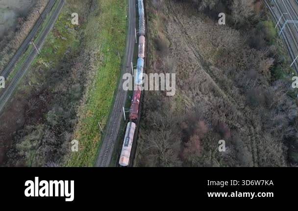 Aerial view of a winding train track with colorful freight cars ...