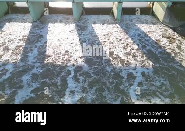 Aerial view of flowing river water cascading through dam gates ...