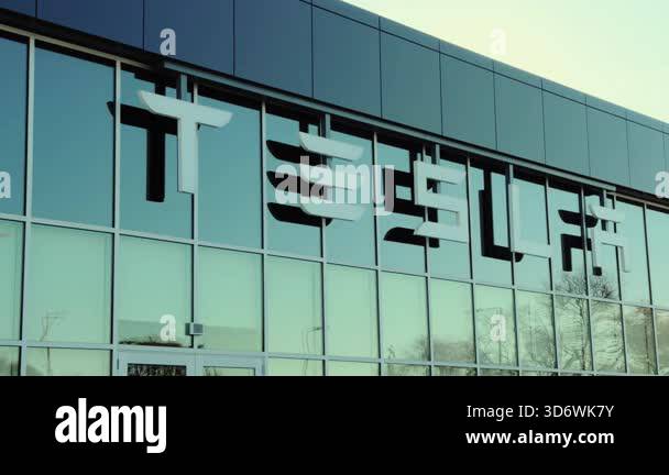 Exterior sign of Tesla dealer at entrance of dealership. Dealership ...