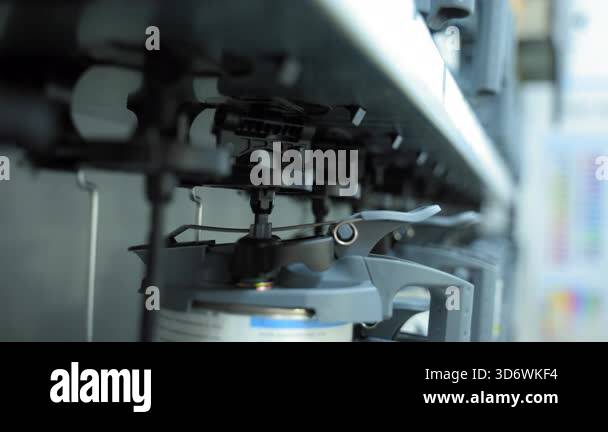 Close-up view of an industrial paint mixing machine. Mechanical arms ...