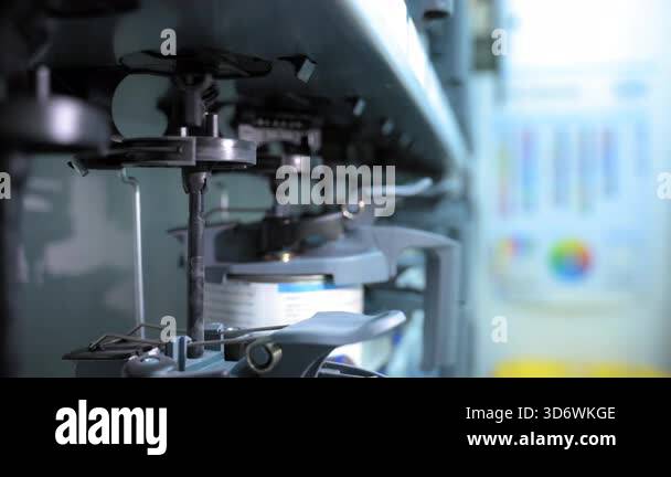 Close-up of an industrial paint mixing machine. Mechanical arms and ...