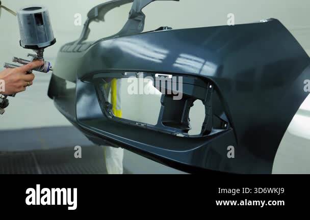 Auto technician spray paint or lacquer on car bumper inside clean ...