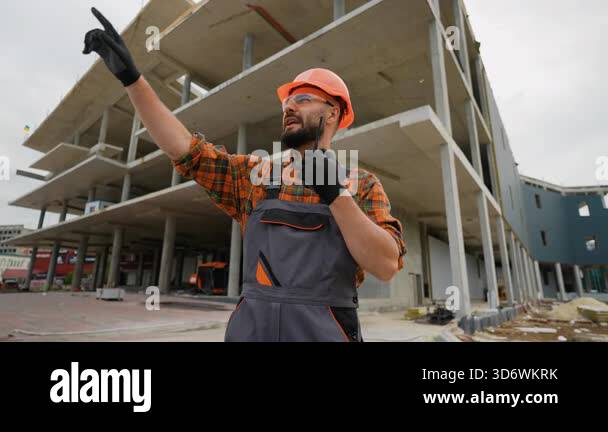 Professional male engineer in a hard hat giving instructions on a ...