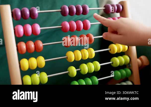 Childs hand moving colorful beads on a classic wooden abacus ...