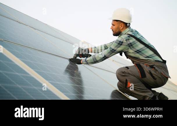 Professional technician in a hard hat and uniform installing ...