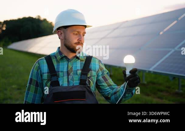 Confident male technician in a hard hat holding a glowing led light ...