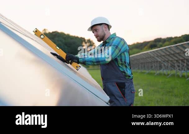 Professional engineer in a hard hat and uniform using a spirit level ...