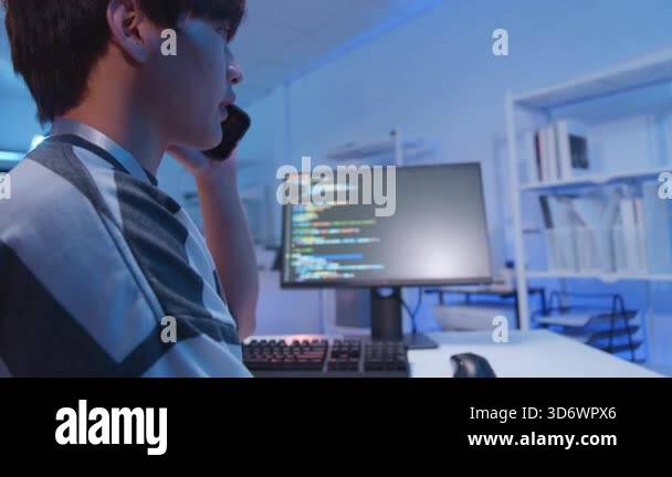 Young male Asian IT freelancer programmer and tech engineer remotely works with computer and ...