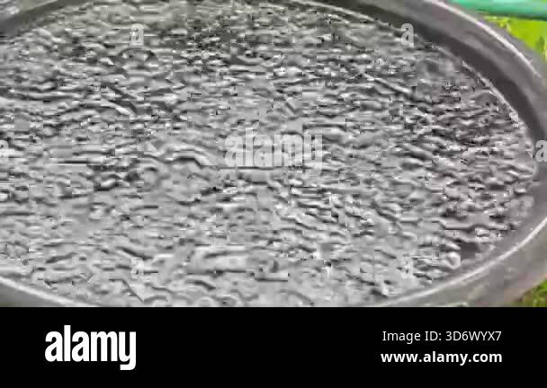 The raindrops hit the water in the black basin, very beautiful Stock ...