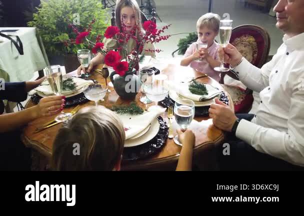 Caucasian family raising glasses around table, cozy dining room with ...