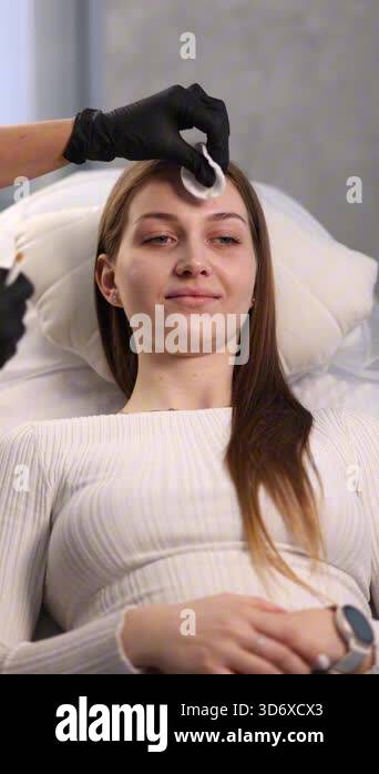 The cosmetologist marks with a pen the injection site for Botox on the ...