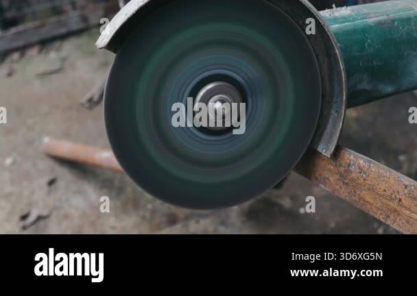spinning grinder wheel cutting metal, close-up of disc slicing pipe ...