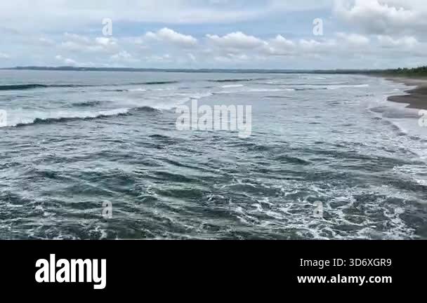 Wide View of Choppy Ocean Waves Crashing onto a Long Beach Shoreline ...