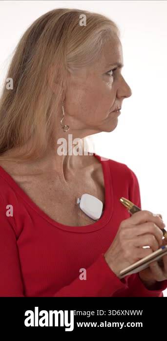 Vertical video of mature woman is engaged in monitoring her heart ...