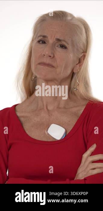 Vertical video portrait of a mature woman with an MCOT heart sensor on ...