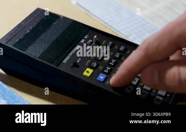 A finger taps the numbers on a vintage calculator keypad. Using vintage ...