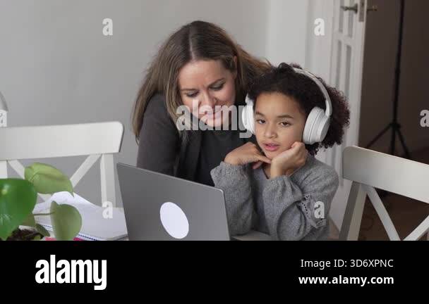 Caucasian mother and African American daughter studying at home, mom ...