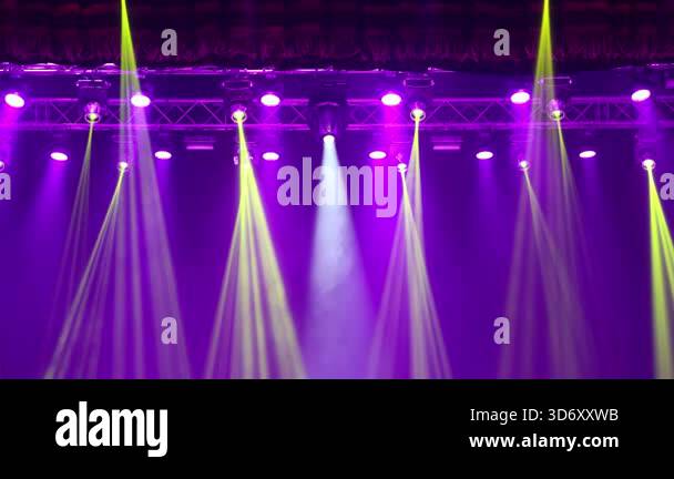 Vibrant multi colored beams of stage lighting cross through concert ...