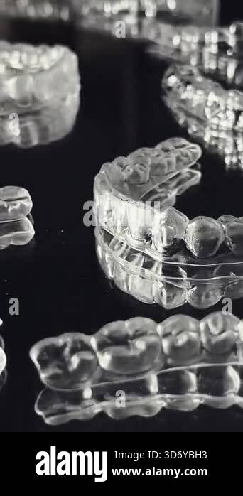 Invisible orthodontics cosmetic brackets on black background. Tooth ...