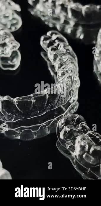 Invisible orthodontics cosmetic brackets on black background. Tooth ...