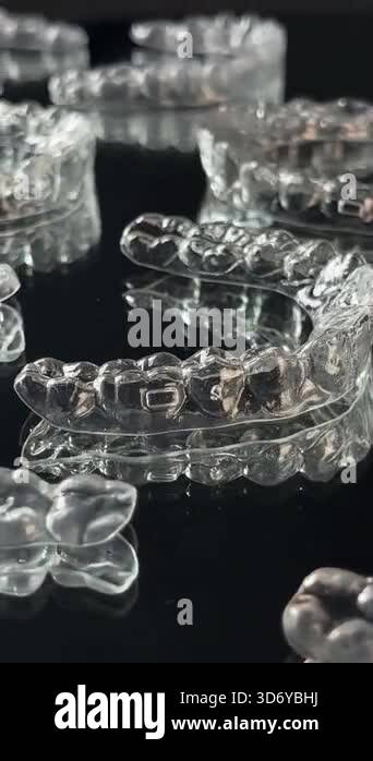 Invisible orthodontics cosmetic brackets on black background. Tooth ...