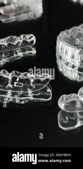 Invisible orthodontics cosmetic brackets on black background. Tooth ...