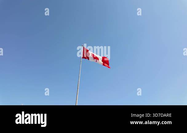 Slow motion footage of the Canadian flag blowing in the wind on a ...