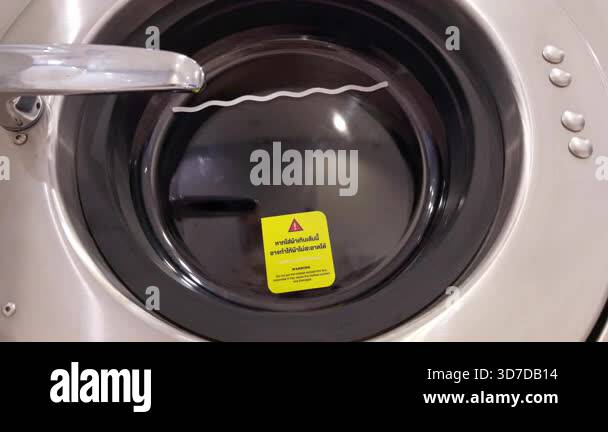 Closed Washing Machine Door with Reflection and Yellow Warning Sticker ...