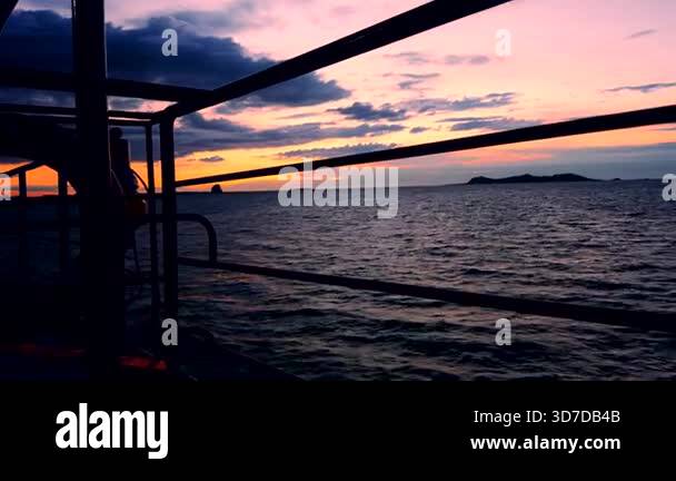 Ferry Deck View Framed by Railings with Vibrant Orange Sunset and ...