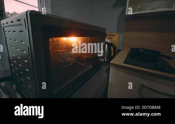 Warm Light Inside Oven with Dish Baking on Countertop in Small Kitchen ...