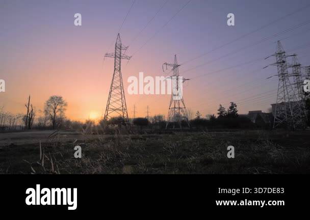 A low-angle shot showing a group of high-voltage transmission towers ...