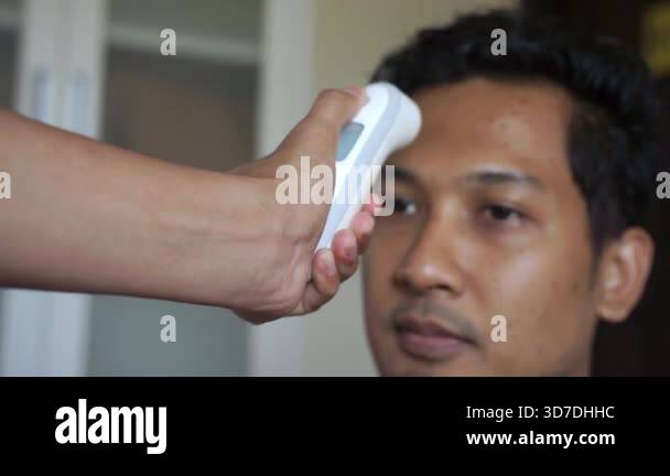 Doctor pointing infrared thermometer ready to check body temperature ...