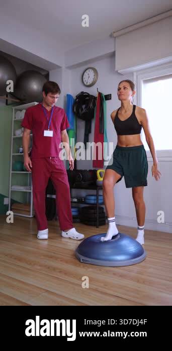 Female patient performing balance and stability exercises on a bosu ...