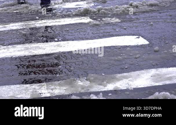 Pedestrian walk in slow motion on over snow and ice gradually melt on a ...