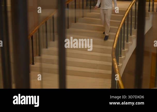 visitor walks downstairs gracefully, contemplative walk through grand ...