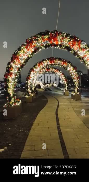 illuminated festive arches over riverside walkway. moscow embankment ...