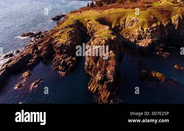 Steep cliffs over calm blue inlet. Steep weathered rock walls border a ...