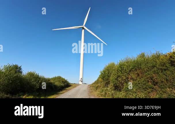 Walking path leading to a wind turbine. Clean energy landscape with ...