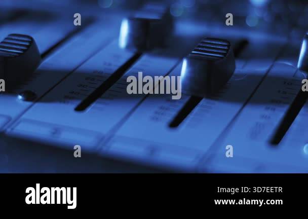 High angle of a producer hand twisting colorful EQ and pan knobs on a ...