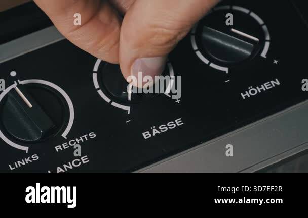 Close-up of a hand adjusting the black Basse or bass dial on a vintage ...