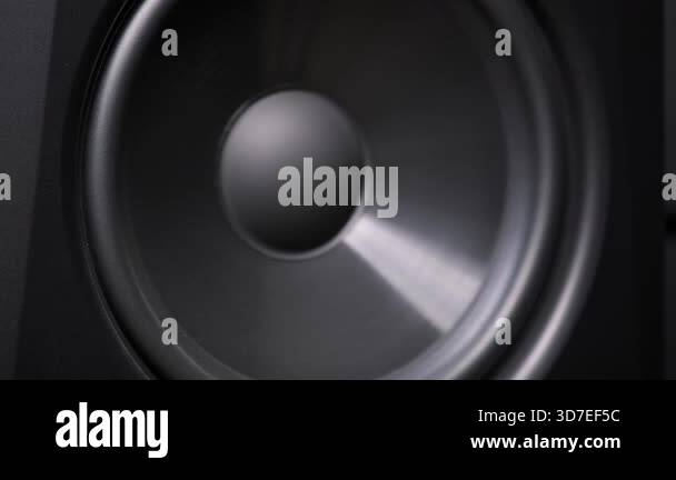Extreme close-up macro view of a black speaker diaphragm pulsing ...