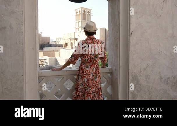 Young woman in ethnic dress and hat exploring Al Seef Park in Dubai ...
