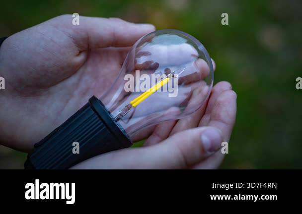 A light bulb in a person's hands. Power outages in Ukraine and Russia ...