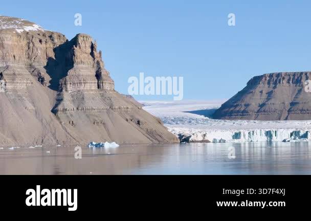 Stunning cliffs tower over calm waters in this serene arctic location ...