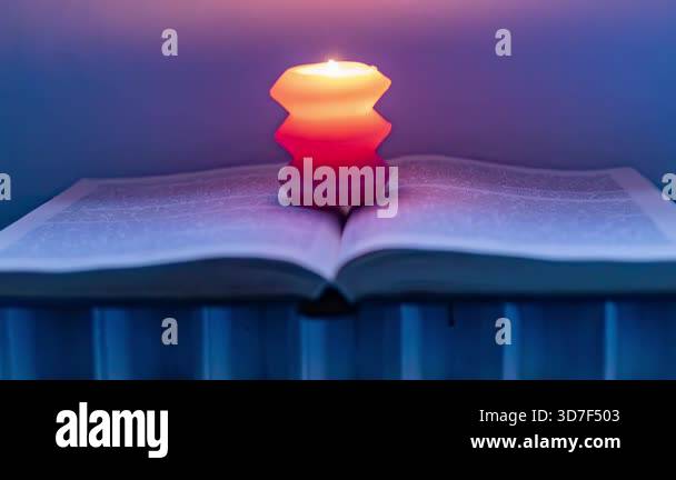 A burning candle on an open book on a radiator. Power and heating ...