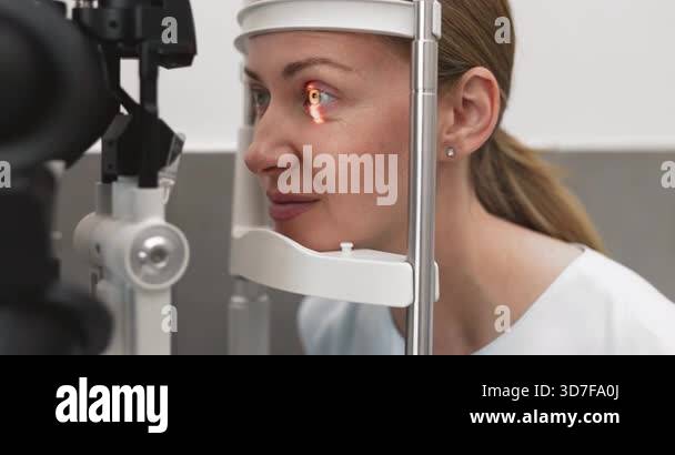 Close up face view of woman during eye examination using slit lamp ...