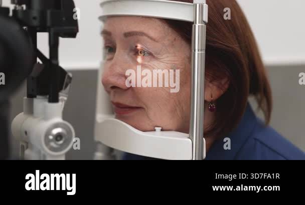 Close up of elderly woman passing eye health examination using slit ...